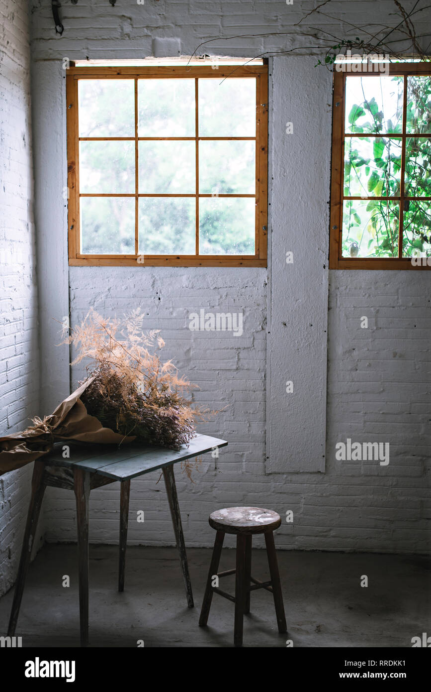 Concept of bouquet of dry coniferous twigs in craft paper on table near ...
