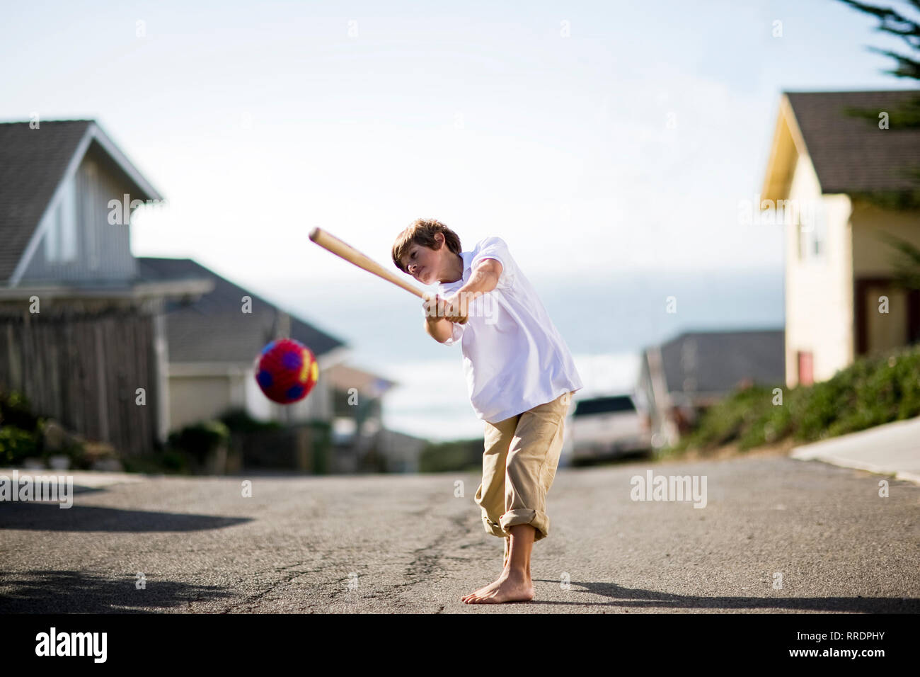 Young boy hitting a ball with a baseball bat Stock Photo - Alamy