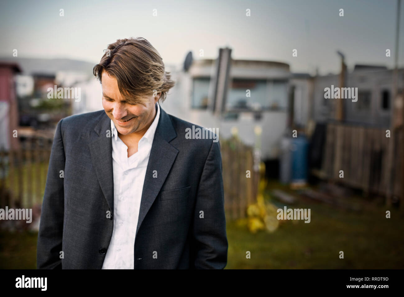 Smiling mid-adult man looking downward Stock Photo - Alamy
