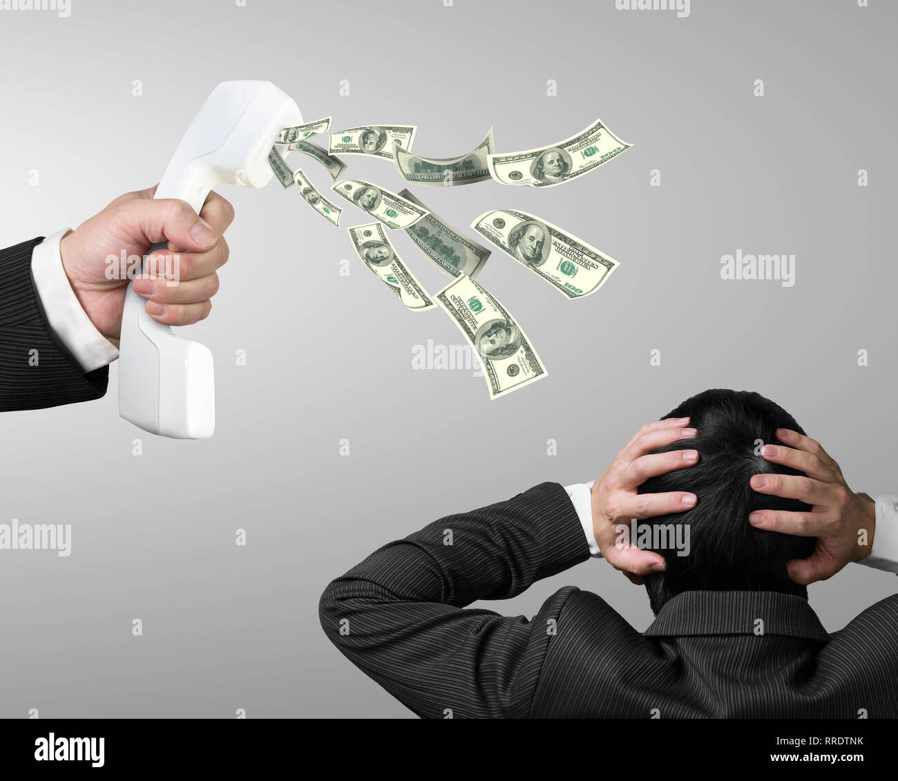 Hand holding white telephone handset with money spraying out to another ...