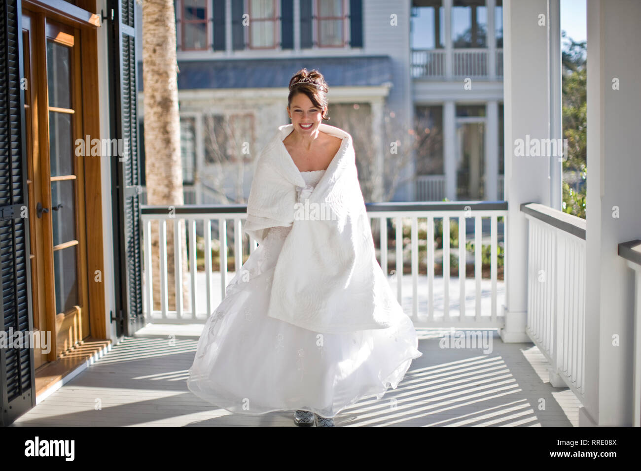 Bride standing on deck wrapped in white shawl Stock Photo - Alamy