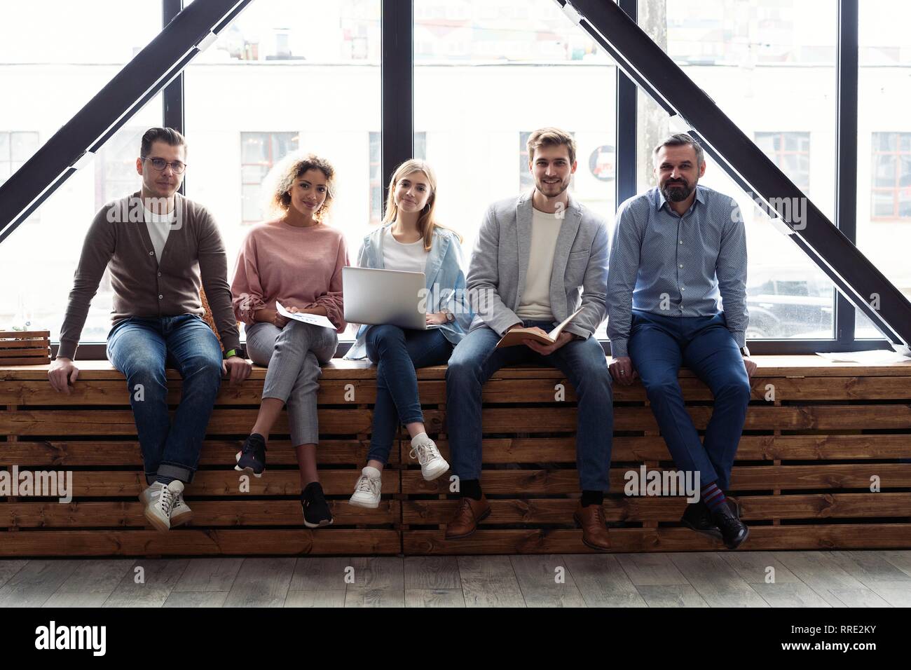 Group Adult Hipsters Friends Sitting Window Sill Using Modern Gadgets. Coworking Process Office ...