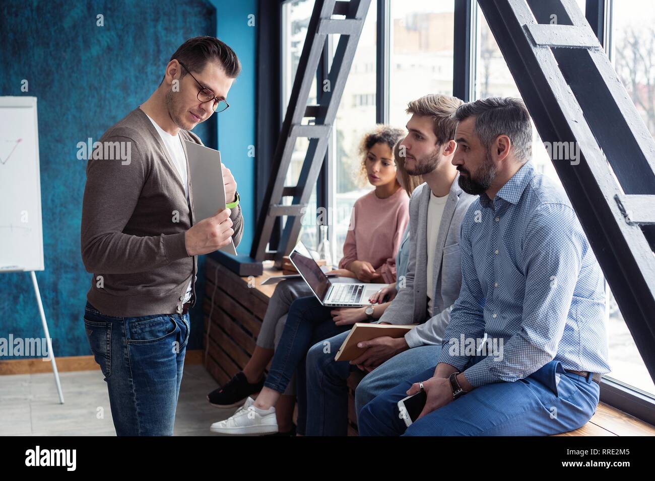 Shot of a male office worker giving creative presentation to his ...