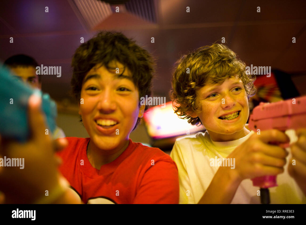 Boys playing arcade game Stock Photo - Alamy