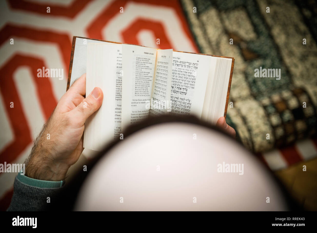 Reading book view from above of Jewish male wearing Kippah praying ...