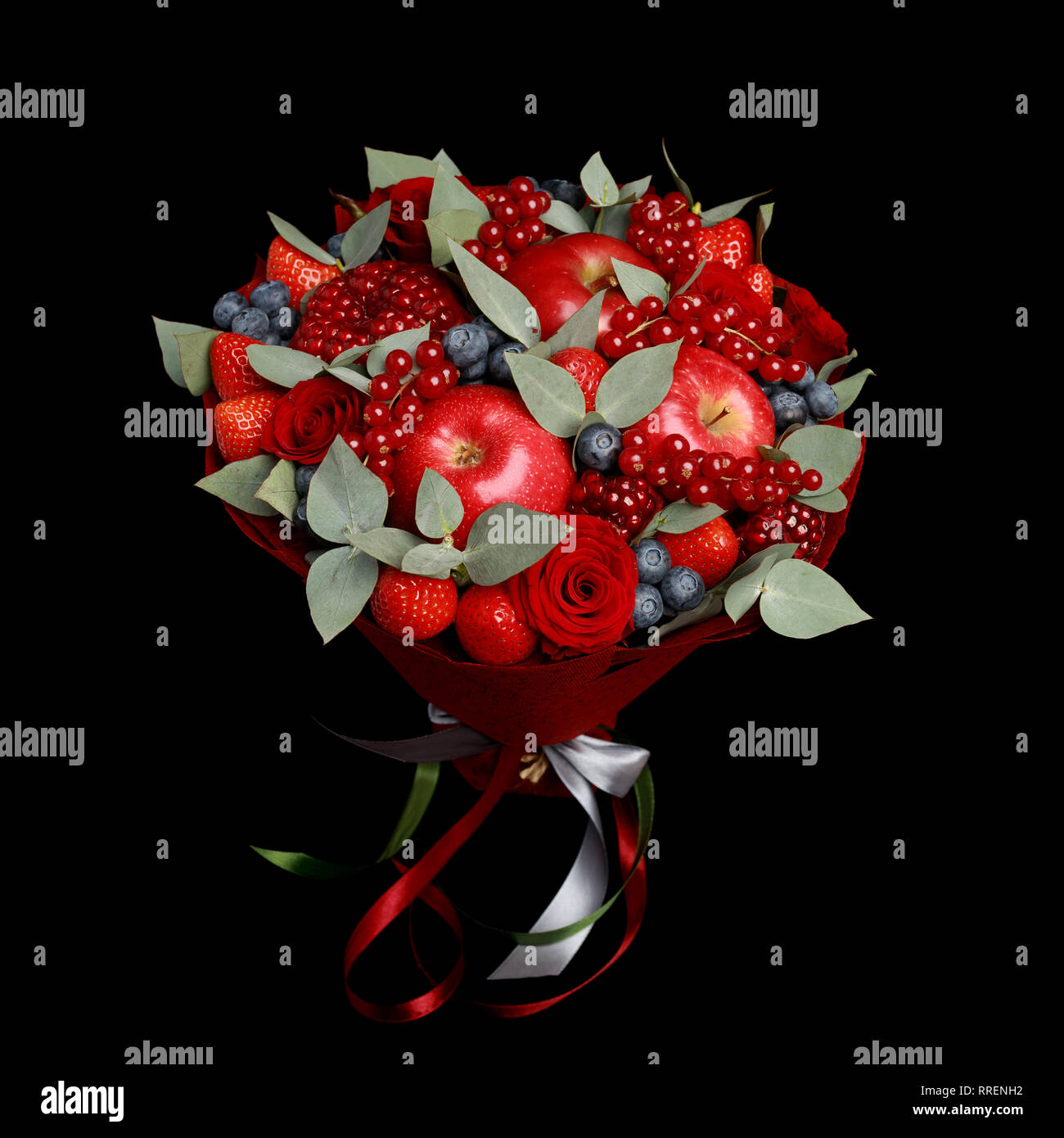 Beautiful bright red edible bouquet of fruits and flowers on a black ...
