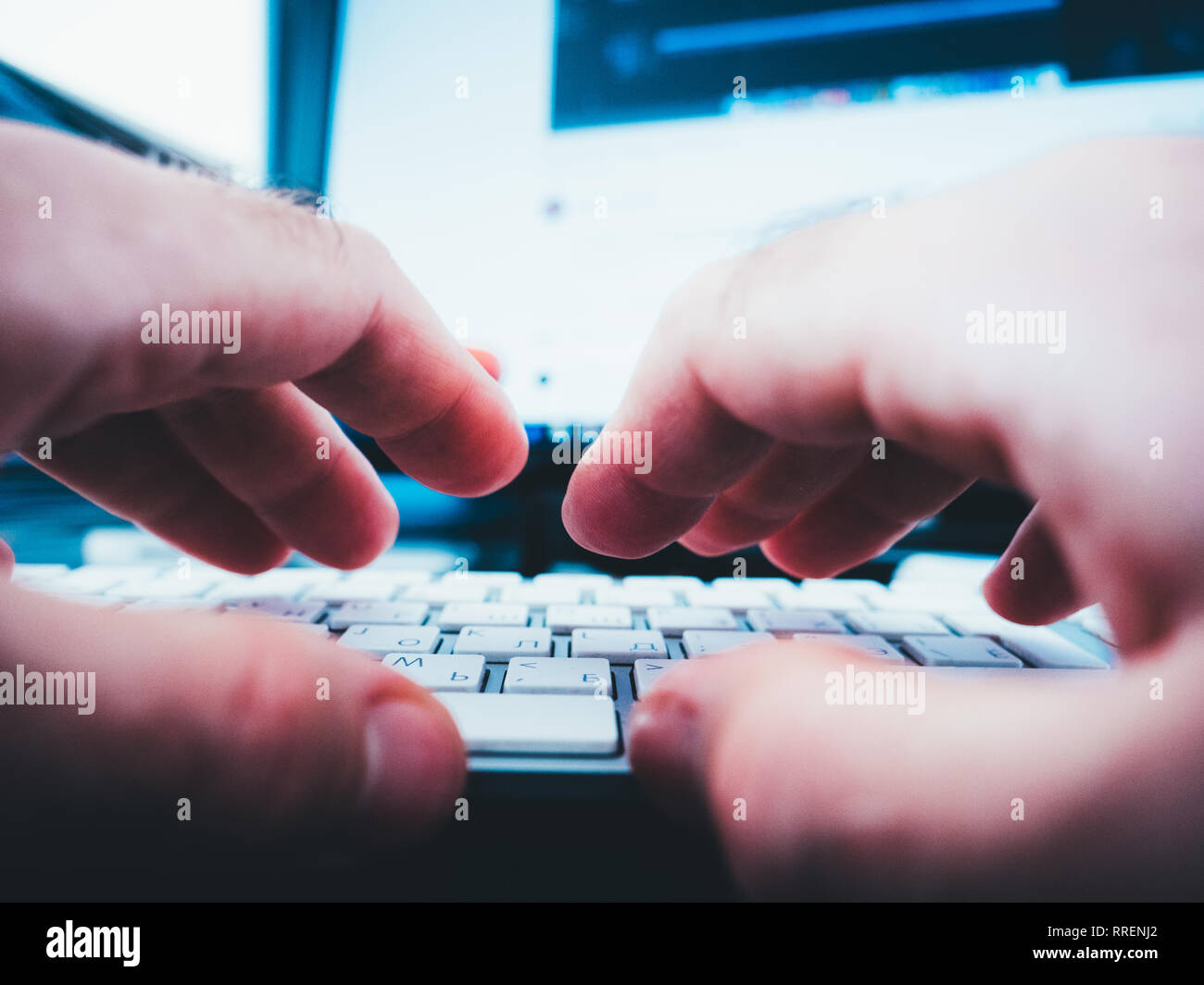 Blue modern colorcast of male hands working on computer keyboard ...