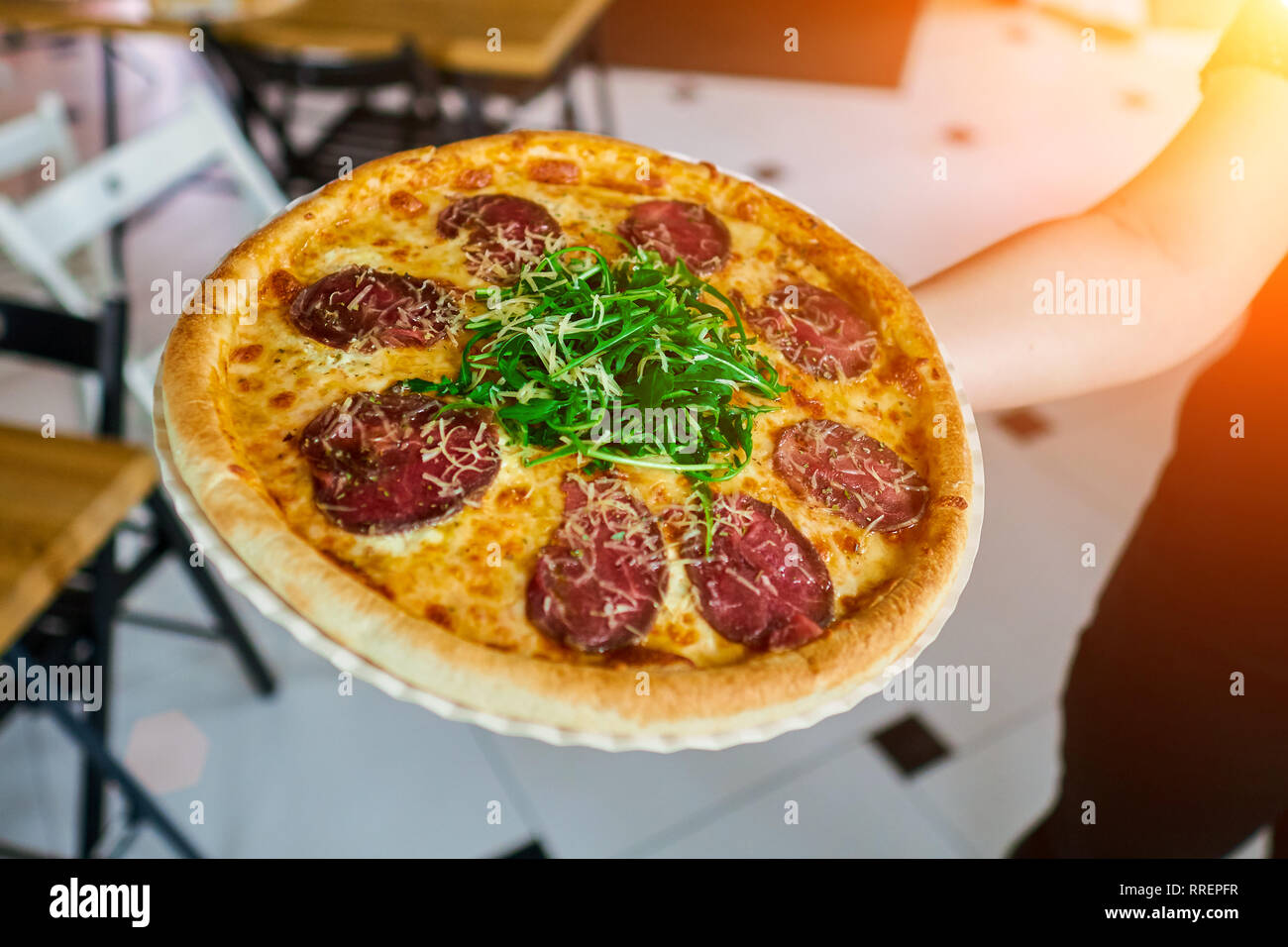 the waiter carries the pizza to the client Stock Photo - Alamy