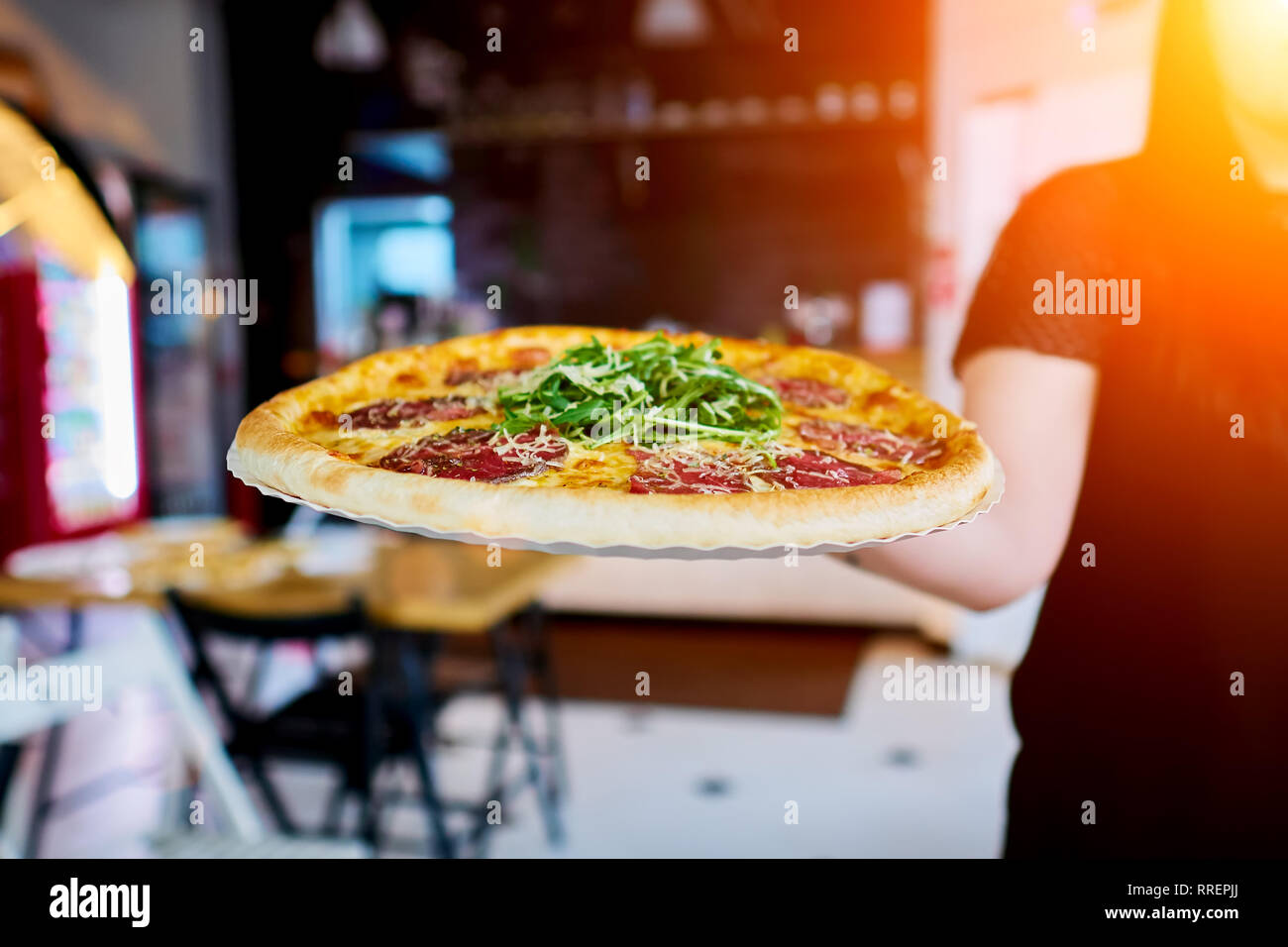 the waiter carries the pizza to the client Stock Photo - Alamy