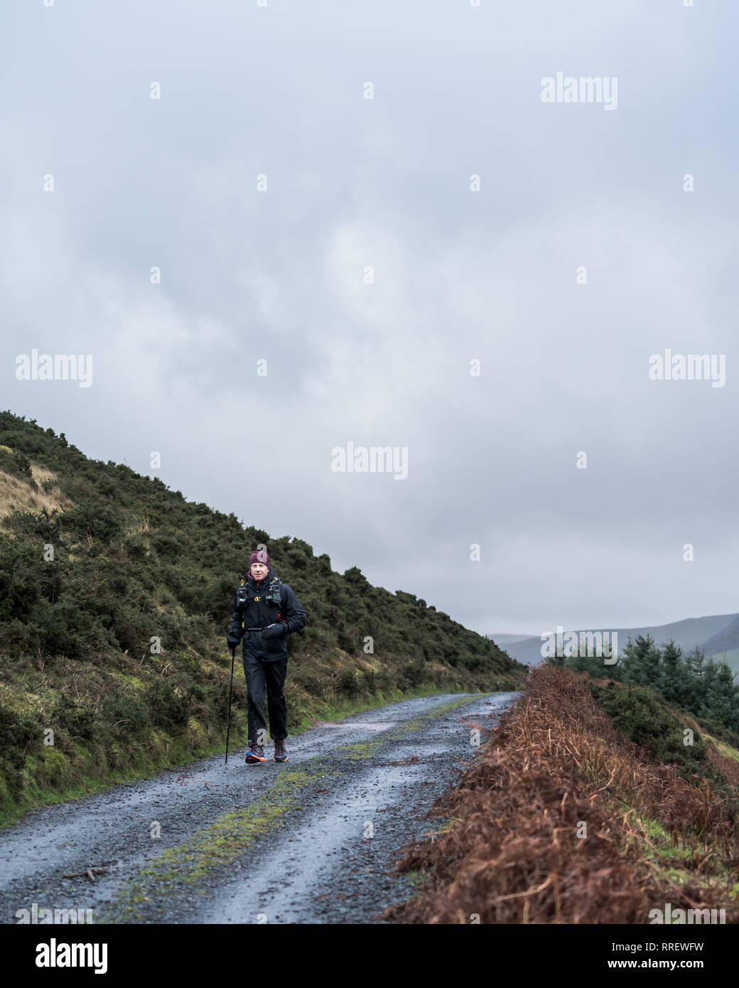 Man running along gravel trail during ultramarathon race in winter ...