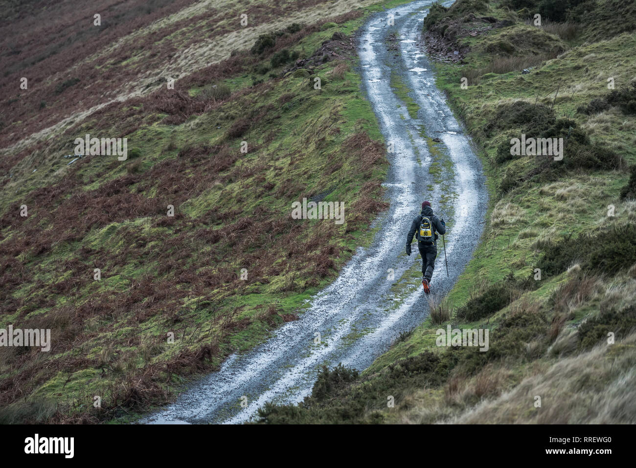Man running along gravel trail during ultramarathon race in winter ...