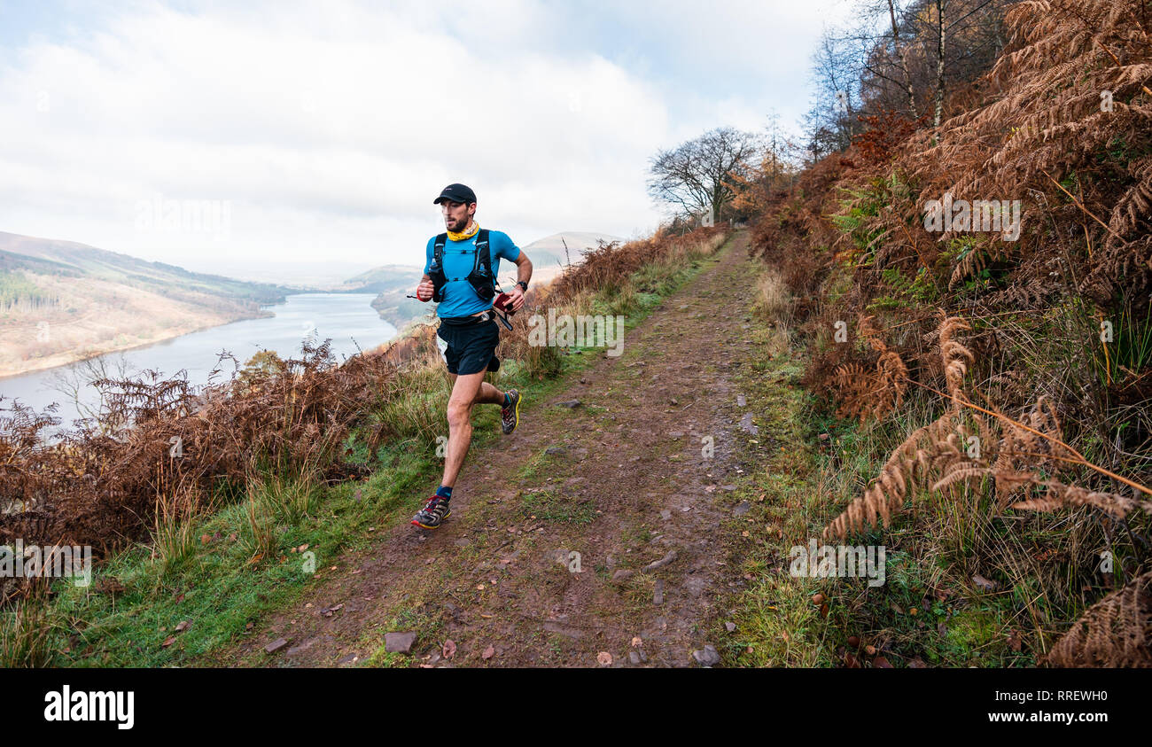 Man trail running through landscape along path Stock Photo - Alamy