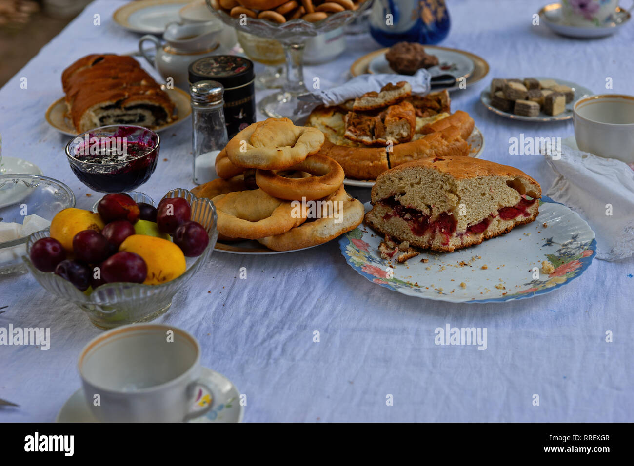 Details of a tea table. Tea service, utensils, plates, and vases filled ...