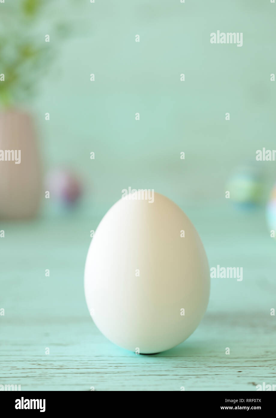 Easter egg standing on its blunt end, decorated in white. Close-up view ...