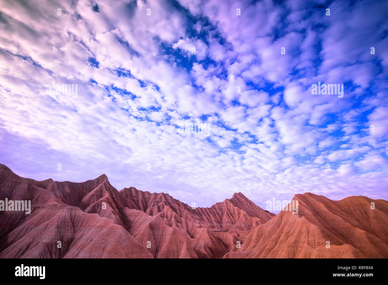 Peak of stone mountain and amazing azure heaven with clouds in Bardenas ...