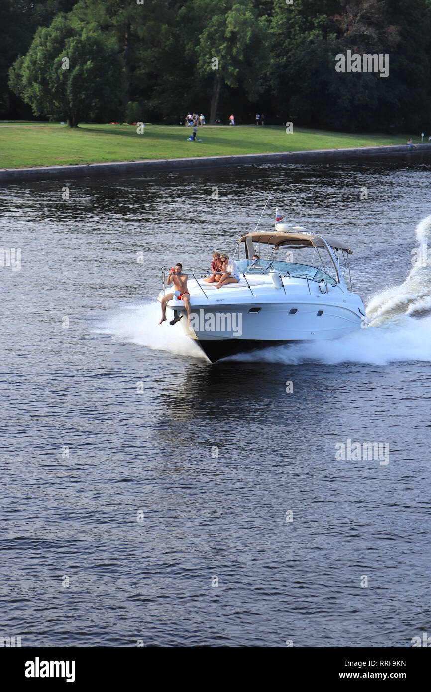 The boat is moving along Medium Nevka. Man sitting on nose of the boat ...