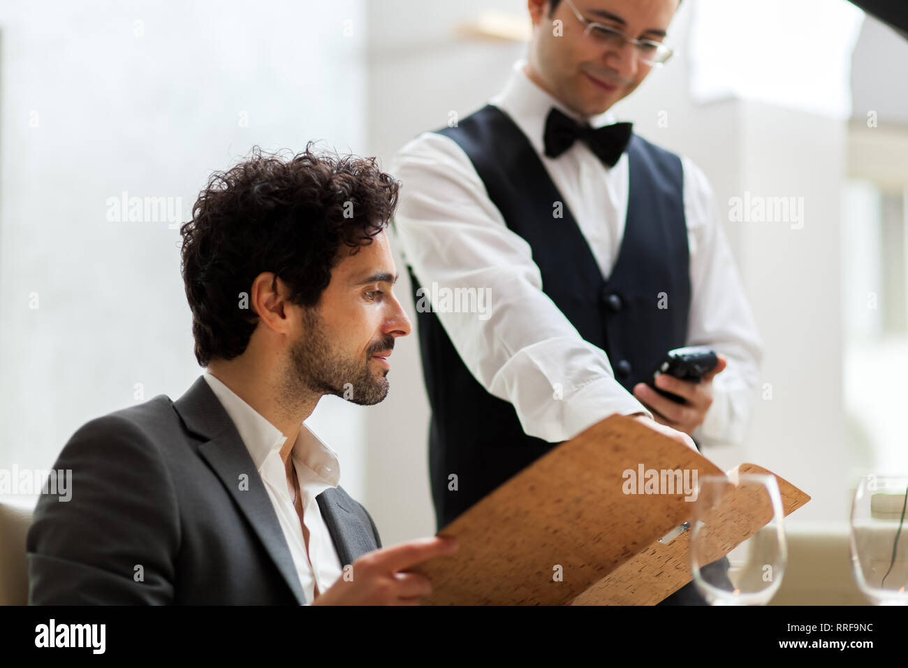 Man looking at a menu in the restaurant Stock Photo - Alamy