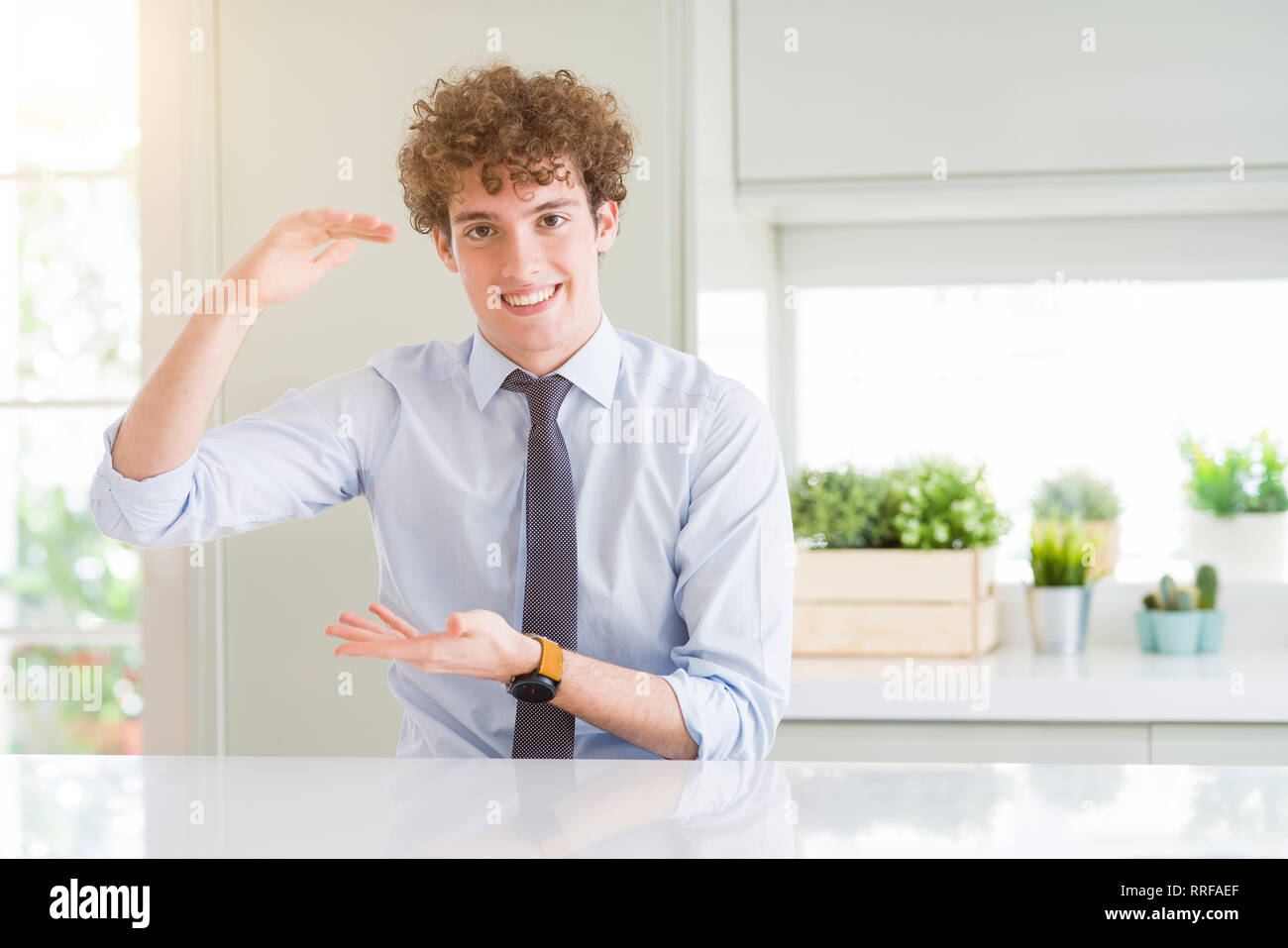 Young business man wearing a tie gesturing with hands showing big and ...