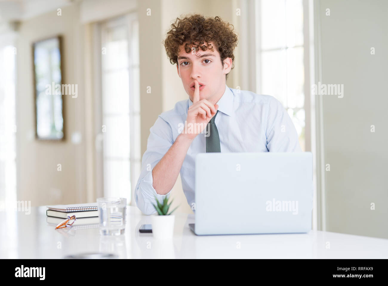 Young business man working with computer laptop at the office asking to ...