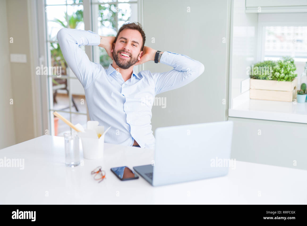 Business man eating take away asian noodles food while working using ...