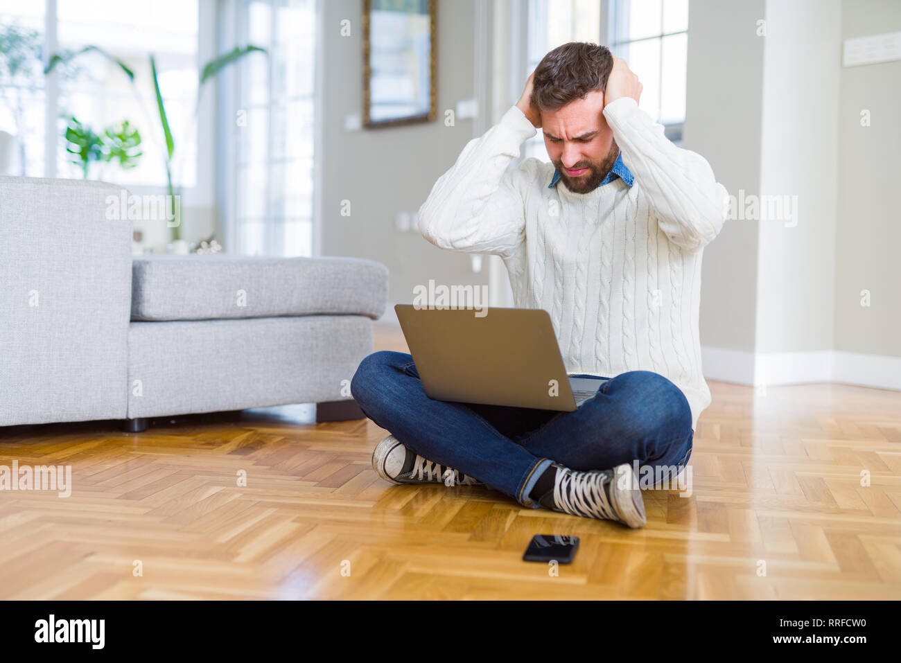 Handsome man wearing working using computer laptop suffering from ...