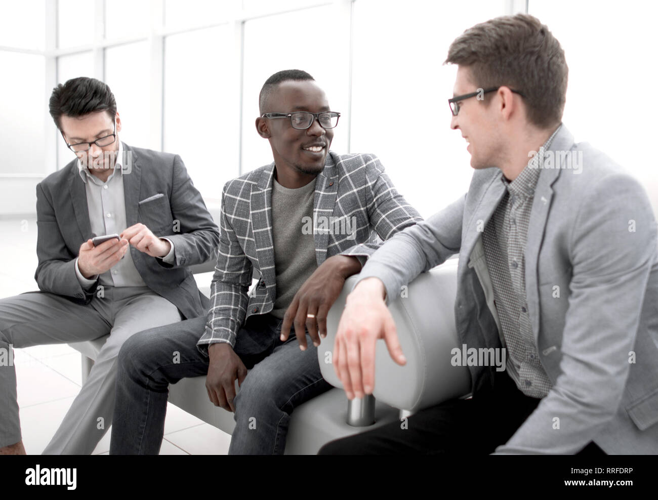 group of employees sitting in the office lobby Stock Photo - Alamy