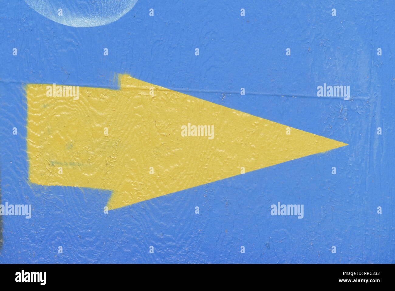 Yellow arrow, direction sign, blue background, painted on wall Stock ...