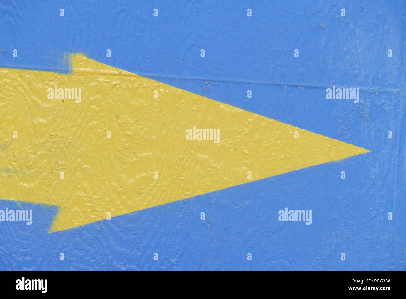 Yellow arrow, direction sign, blue background, painted on wall Stock ...