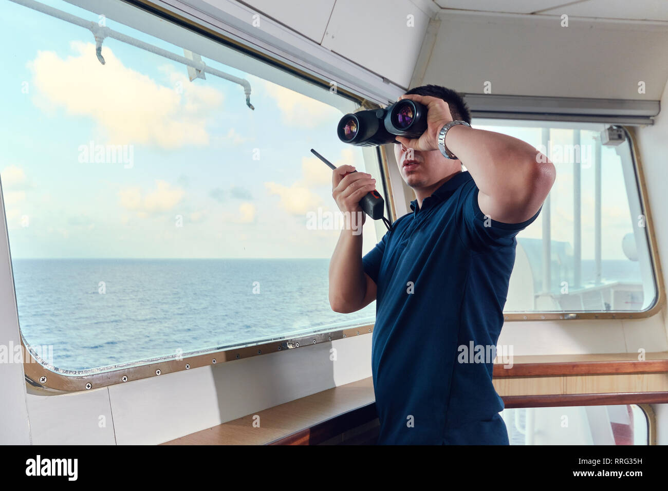 Navigation offcier Pilot on the bridge of a ship underway with ...