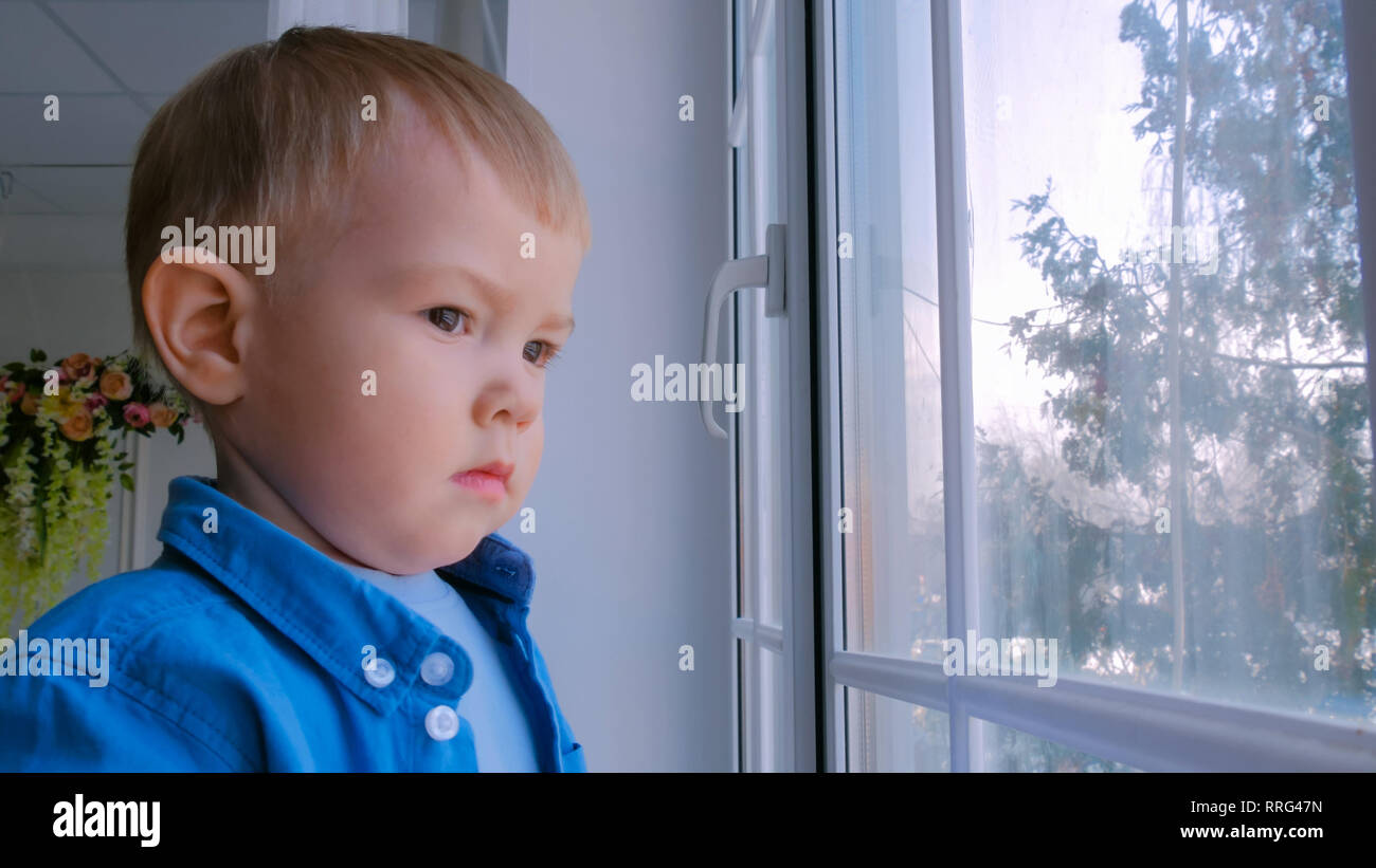 Boy looking through window hi-res stock photography and images - Alamy
