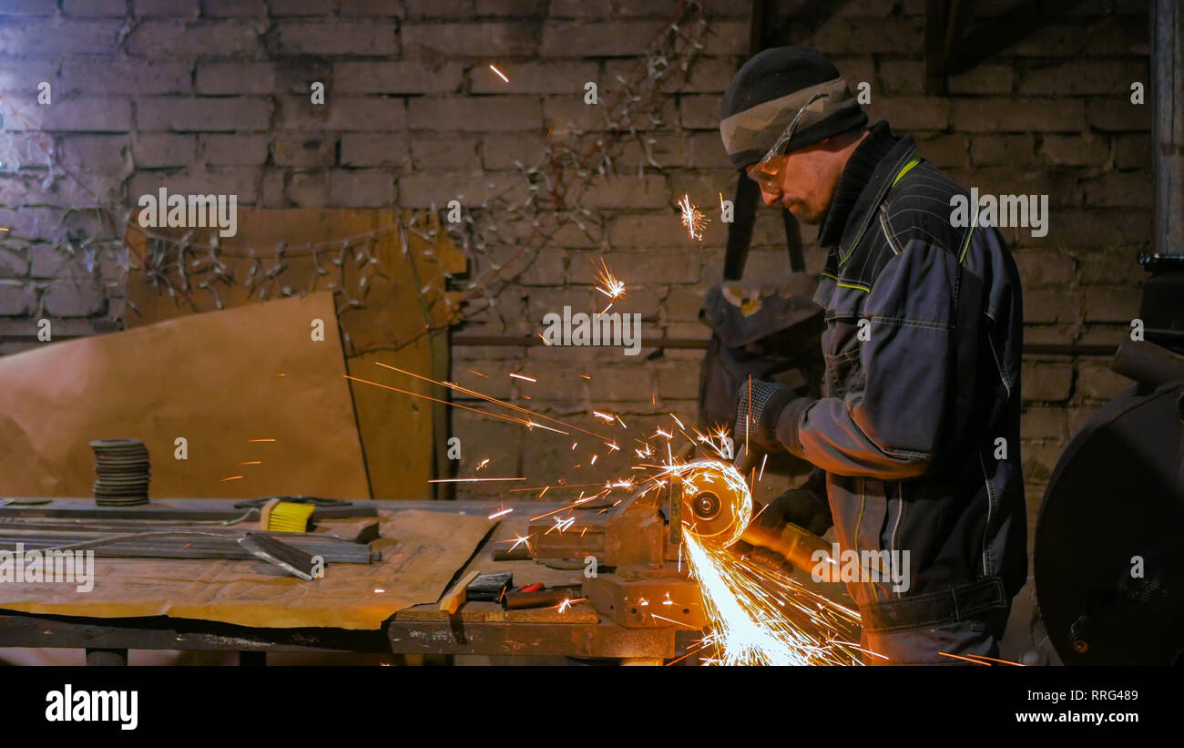 Blacksmith sawing metal with hand circular saw Stock Photo - Alamy