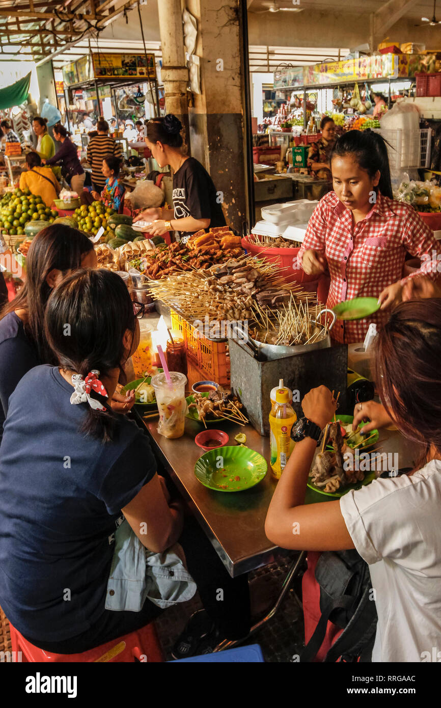 Young women eating sate at a stall in the eating area of this huge old ...