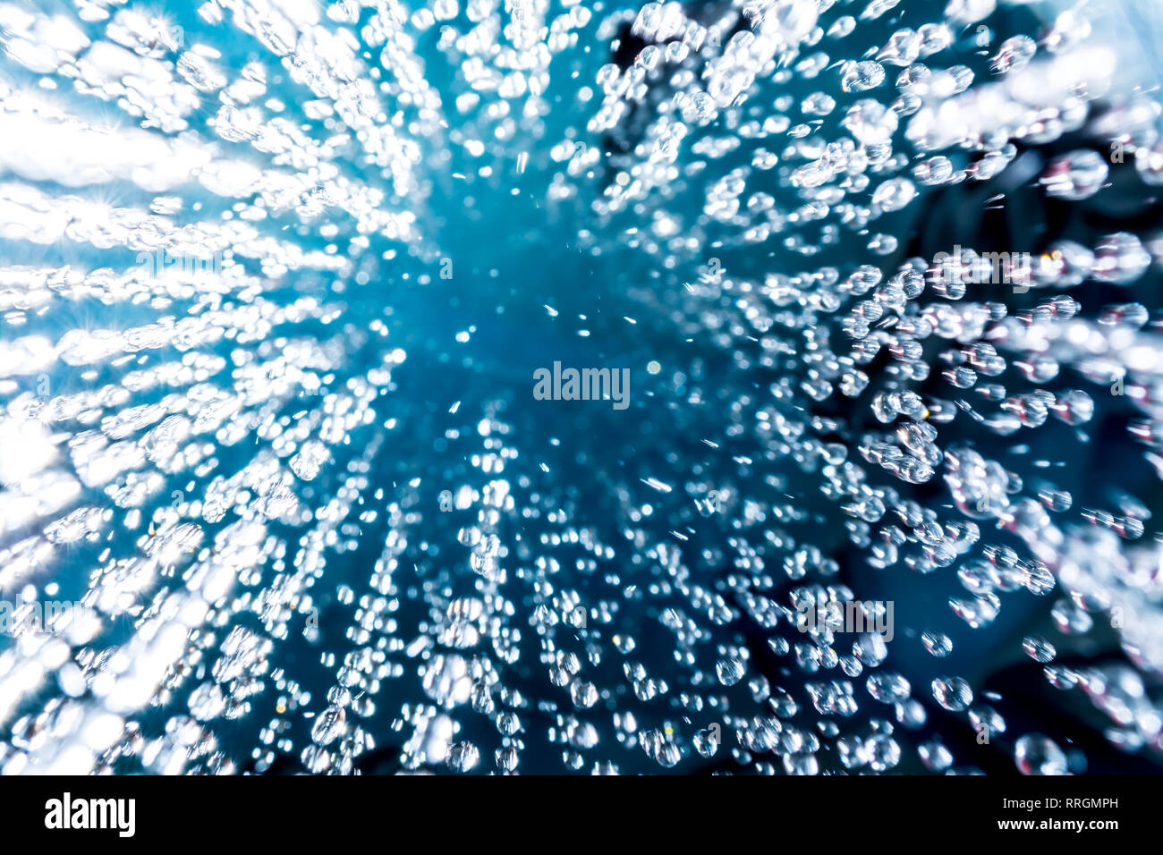 Abstract background of water pouring from above with sun highlights on ...