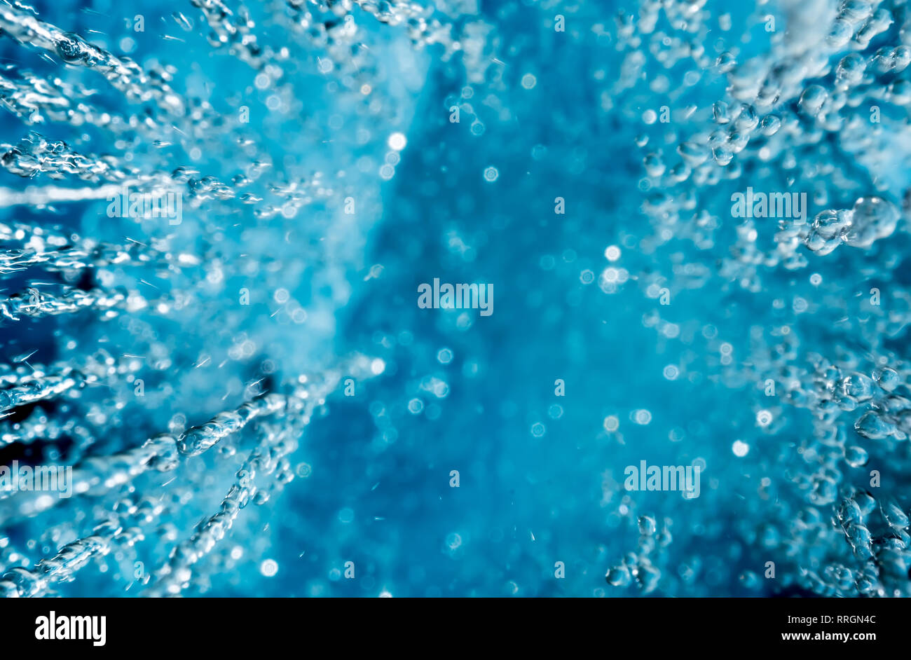 Abstract background of water pouring from above with sun highlights on ...