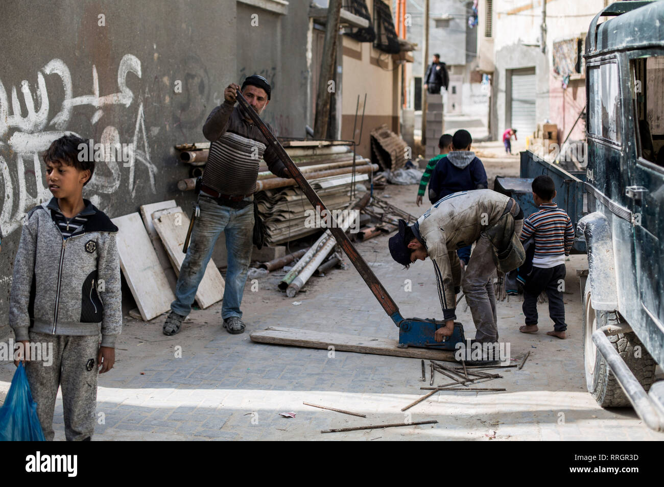 Palestinian men are seen working next to their home in a refugee camp ...
