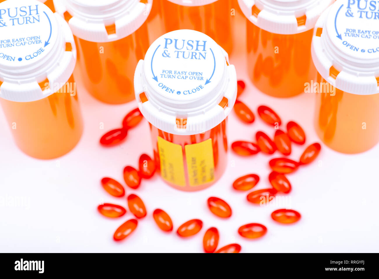 Docusate sodium soft gel capsules next to plastic orange container ...