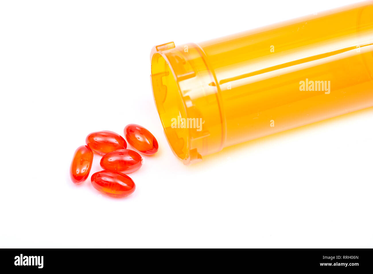 Docusate sodium soft gel capsules next to plastic orange container ...