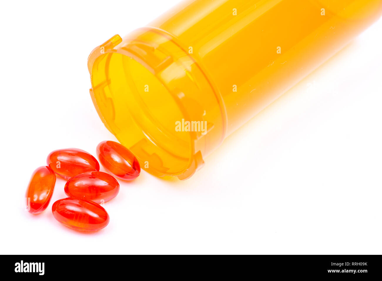 Docusate sodium soft gel capsules next to plastic orange container ...