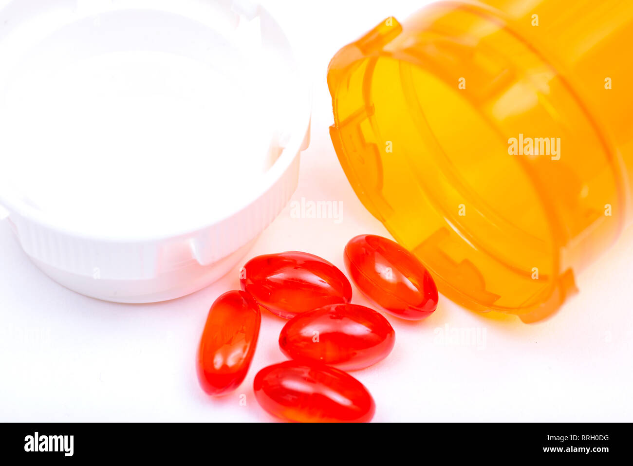 Docusate sodium soft gel capsules next to plastic orange container ...