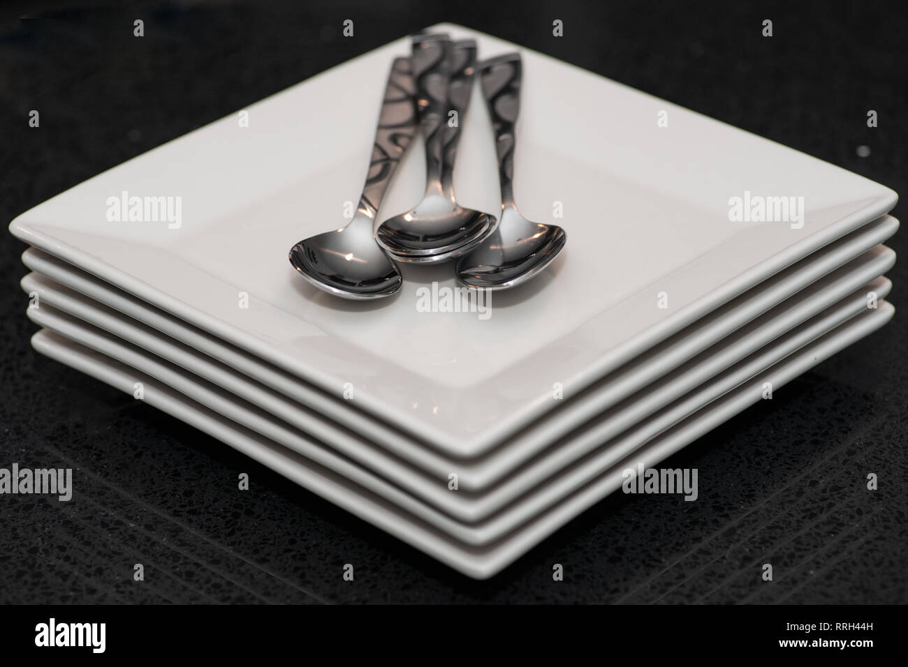 Square dessert plates and silverware on banquet table at business or ...
