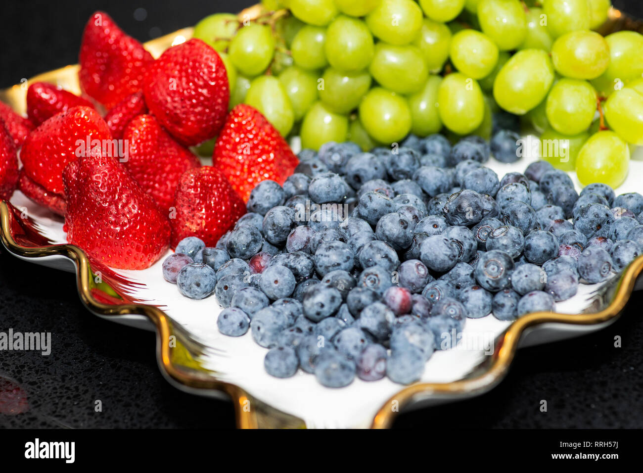 Fresh fruit platter with arranged organic blueberries, strawberries ...