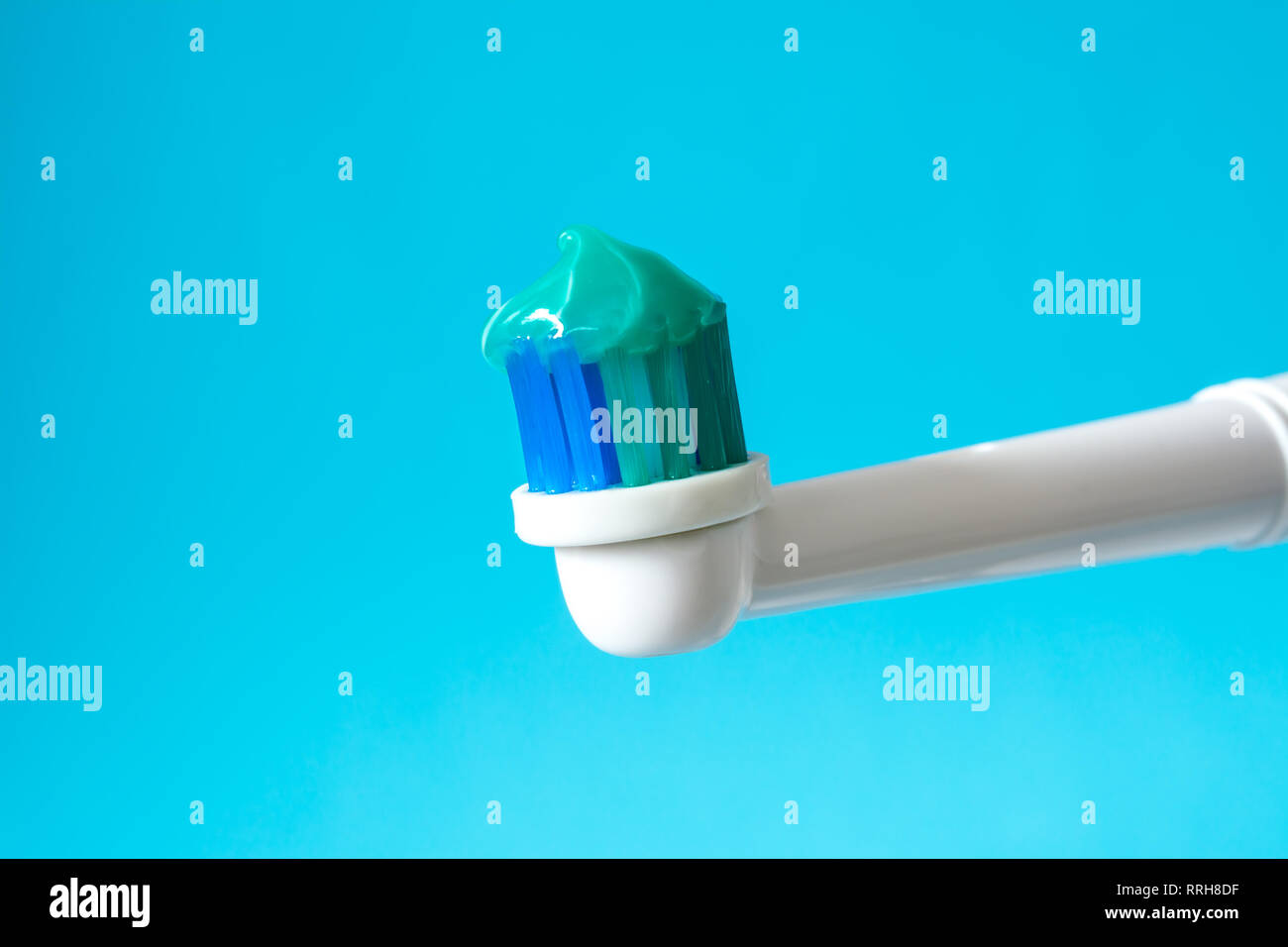 Electric toothbrush with green toothpaste with mint flavor close up on ...