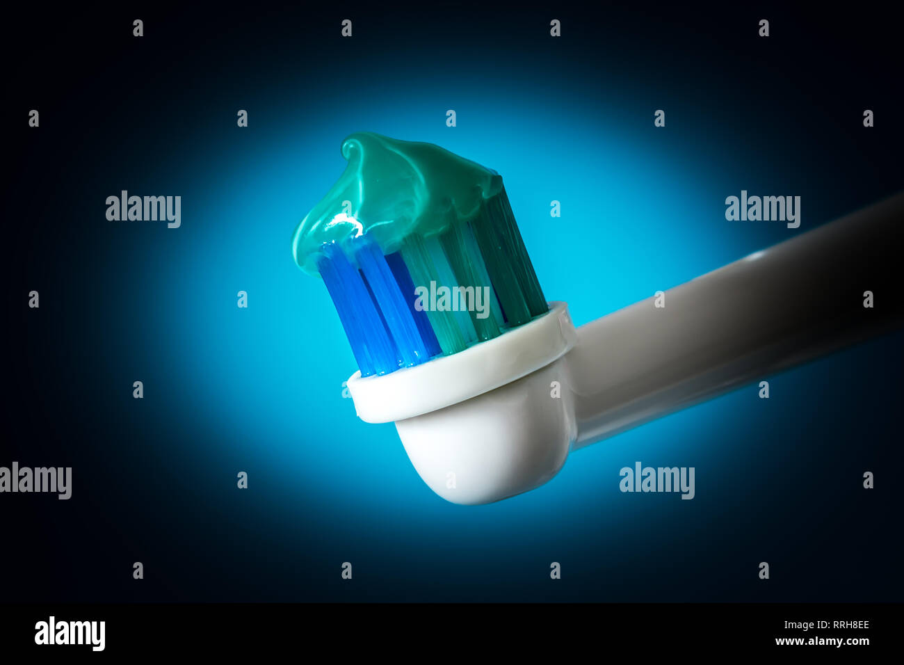 Electric toothbrush with green toothpaste with mint flavor close up on ...