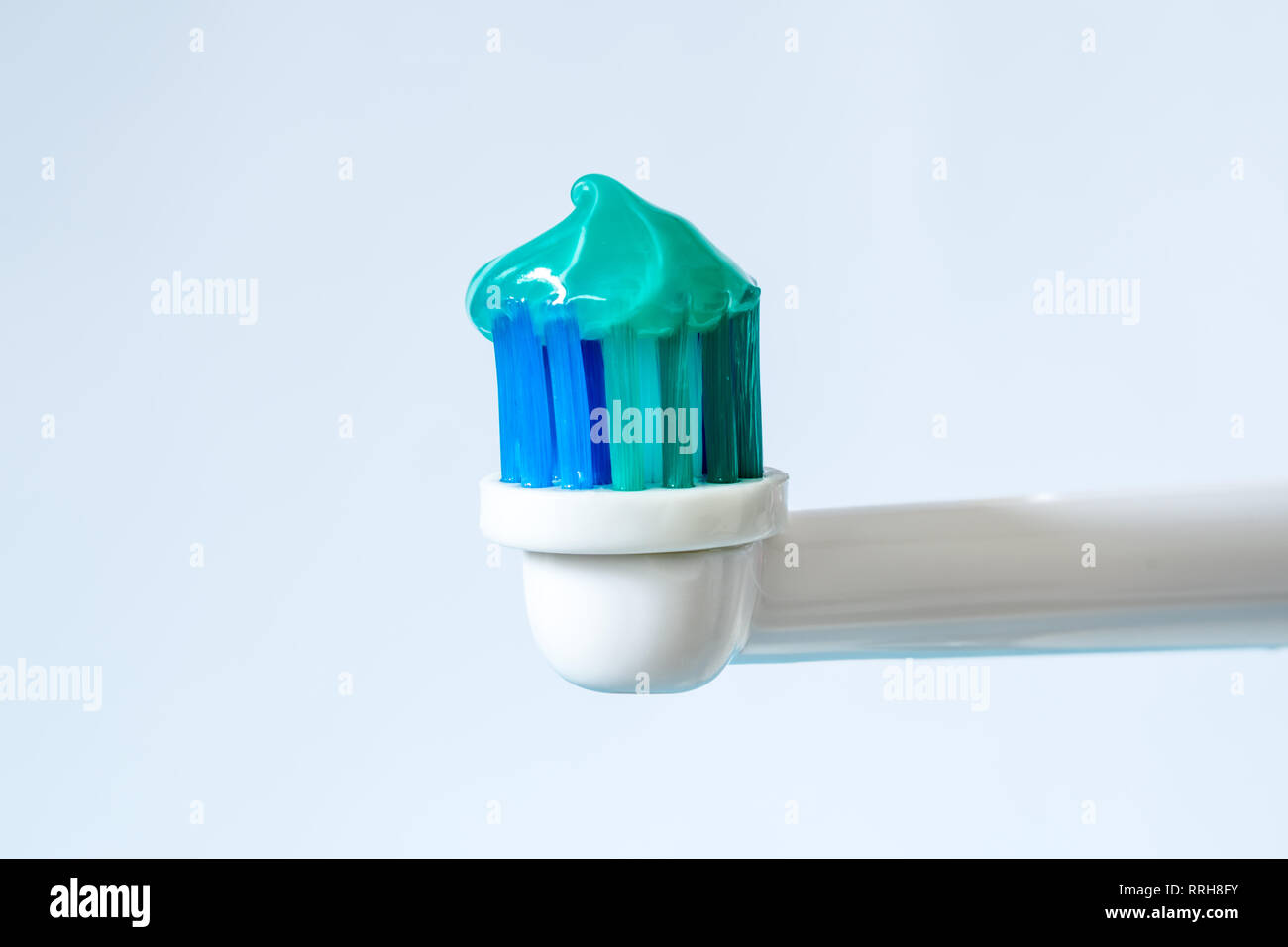 Electric toothbrush with green toothpaste with mint flavor close up on ...