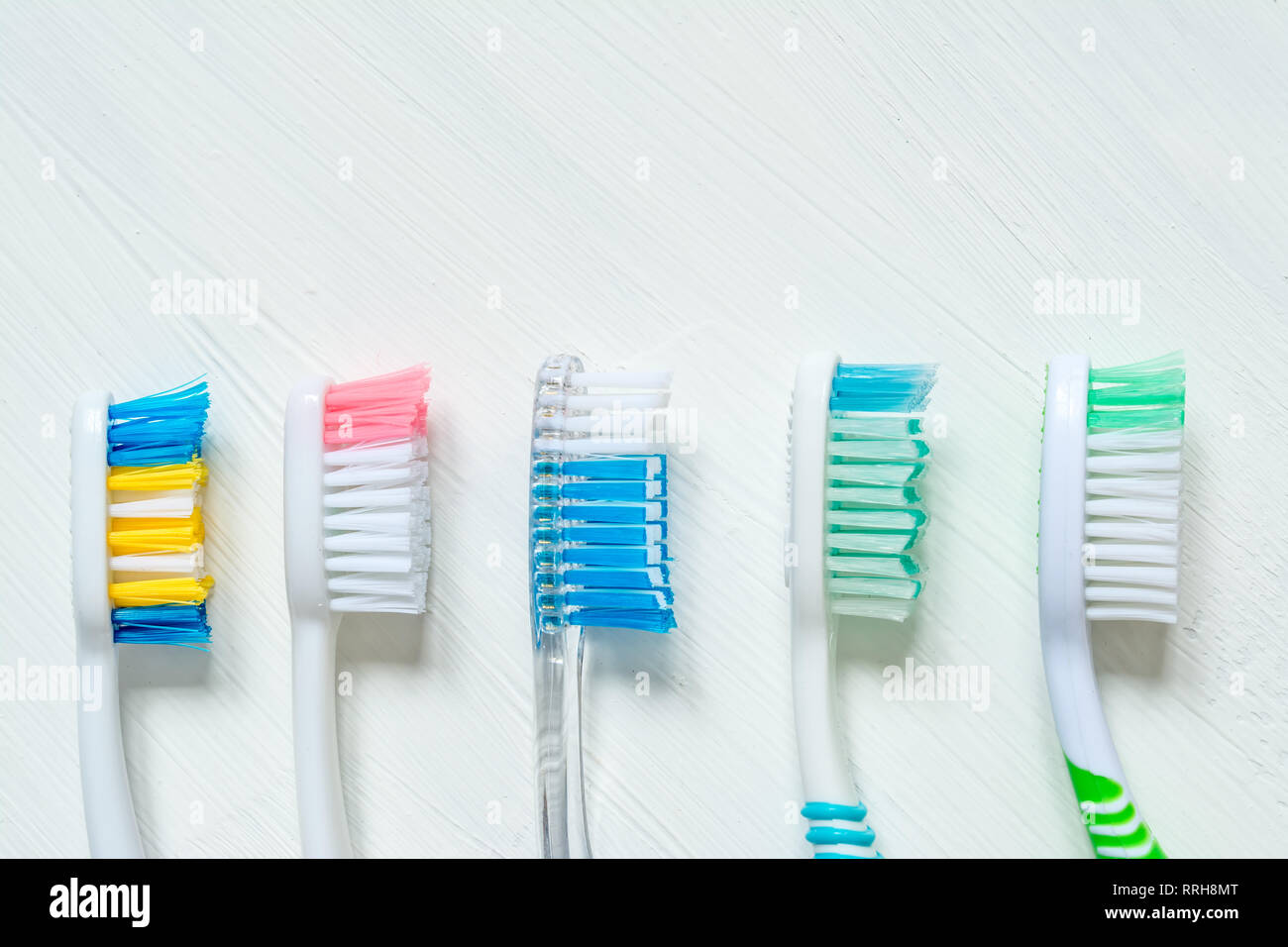Toothbrushes of different colors close up on a white vintage background ...
