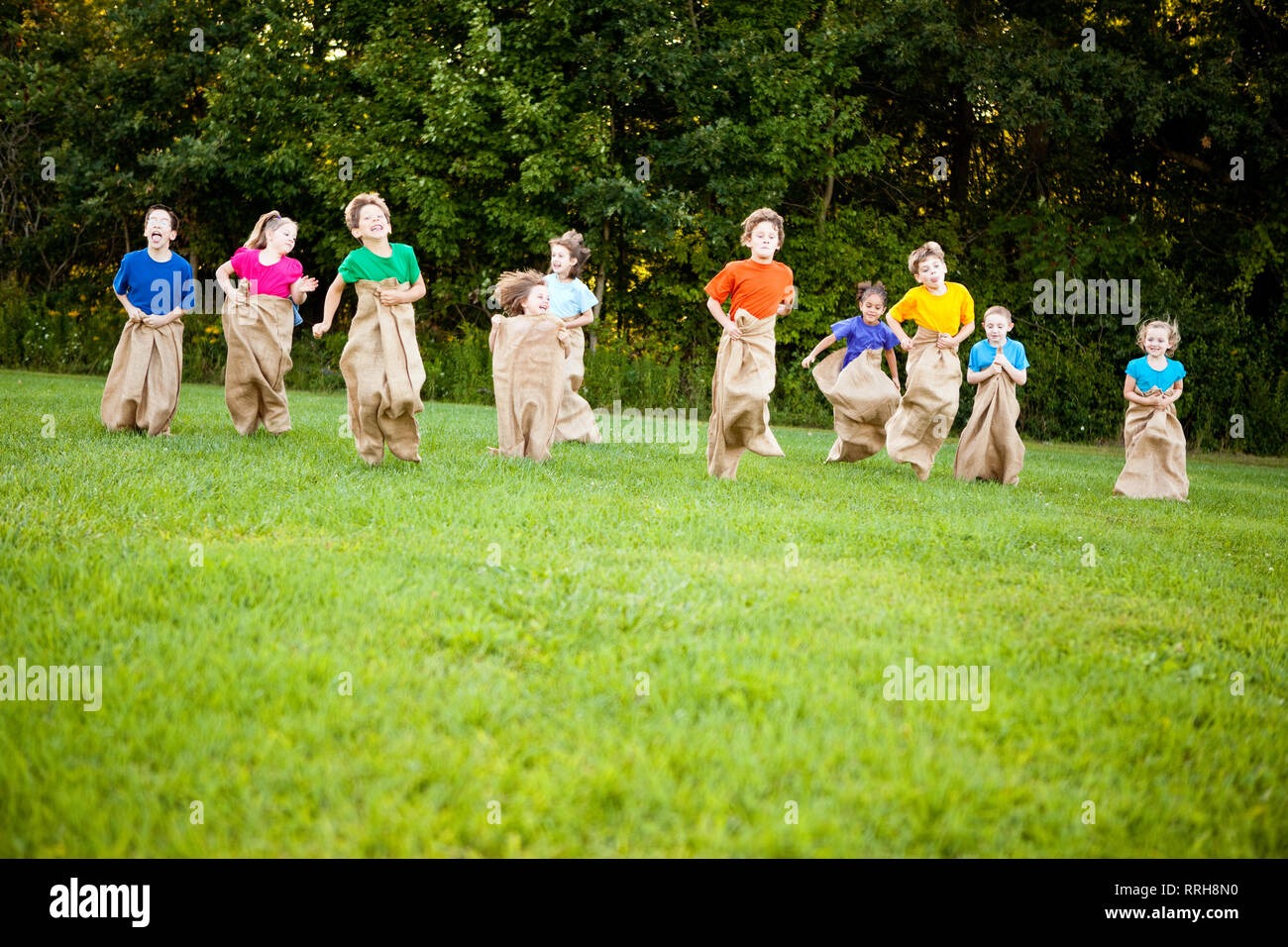 Happy Kids Having Potato Sack Race Outside Stock Photo - Alamy