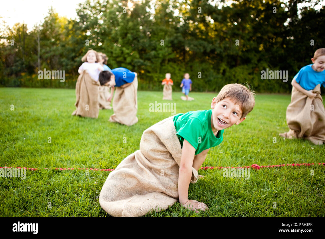 Happy Kids Having Potato Sack Race Outside Stock Photo - Alamy