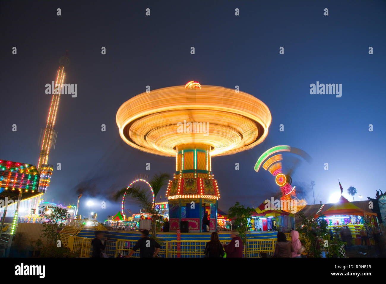 View looking up at the carousel swing ride. Carnival Midway at night ...