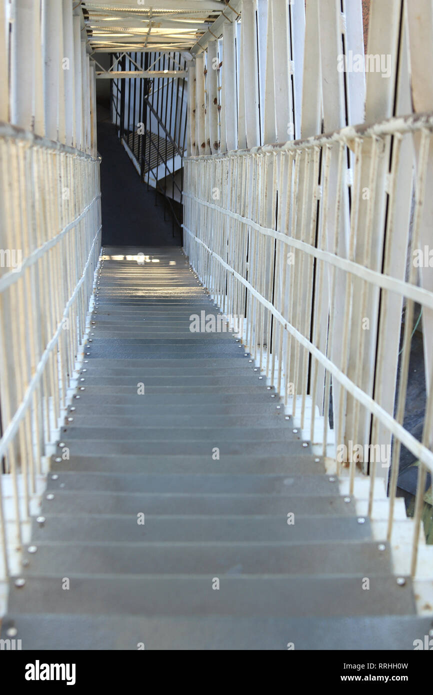 Iron ladder down protected by a cage of steel rods Stock Photo - Alamy