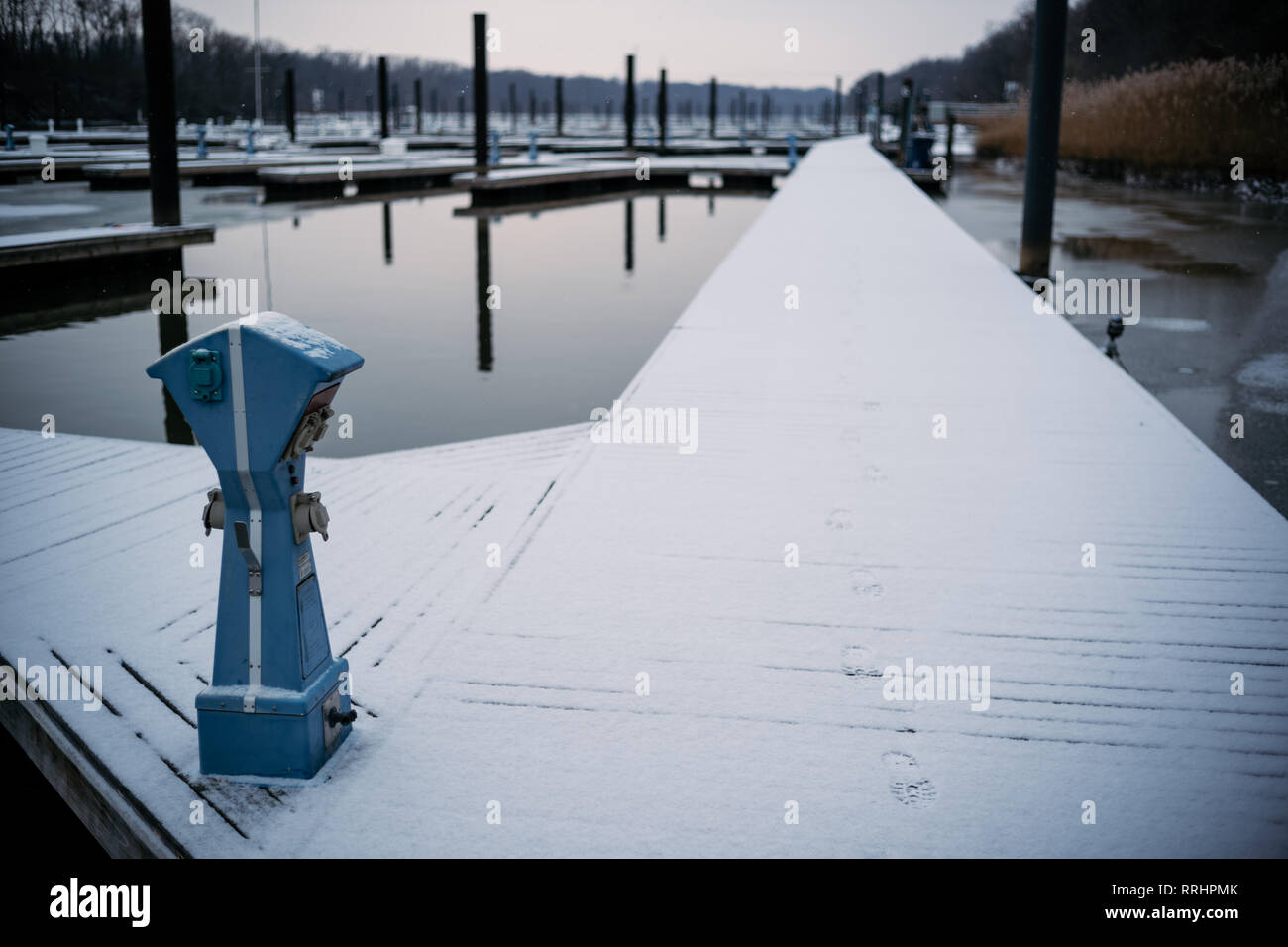 Frigid snow covered docks during winter at quiet east coast marina ...